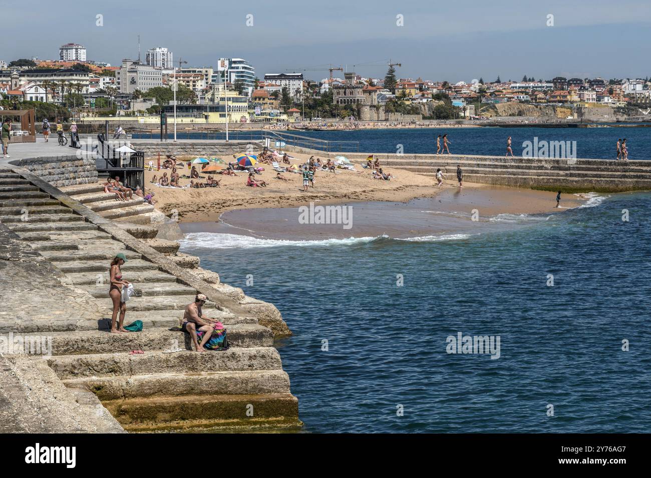 Sunbathers sunbathing on the steps and sand of Praia da Rata in the ...