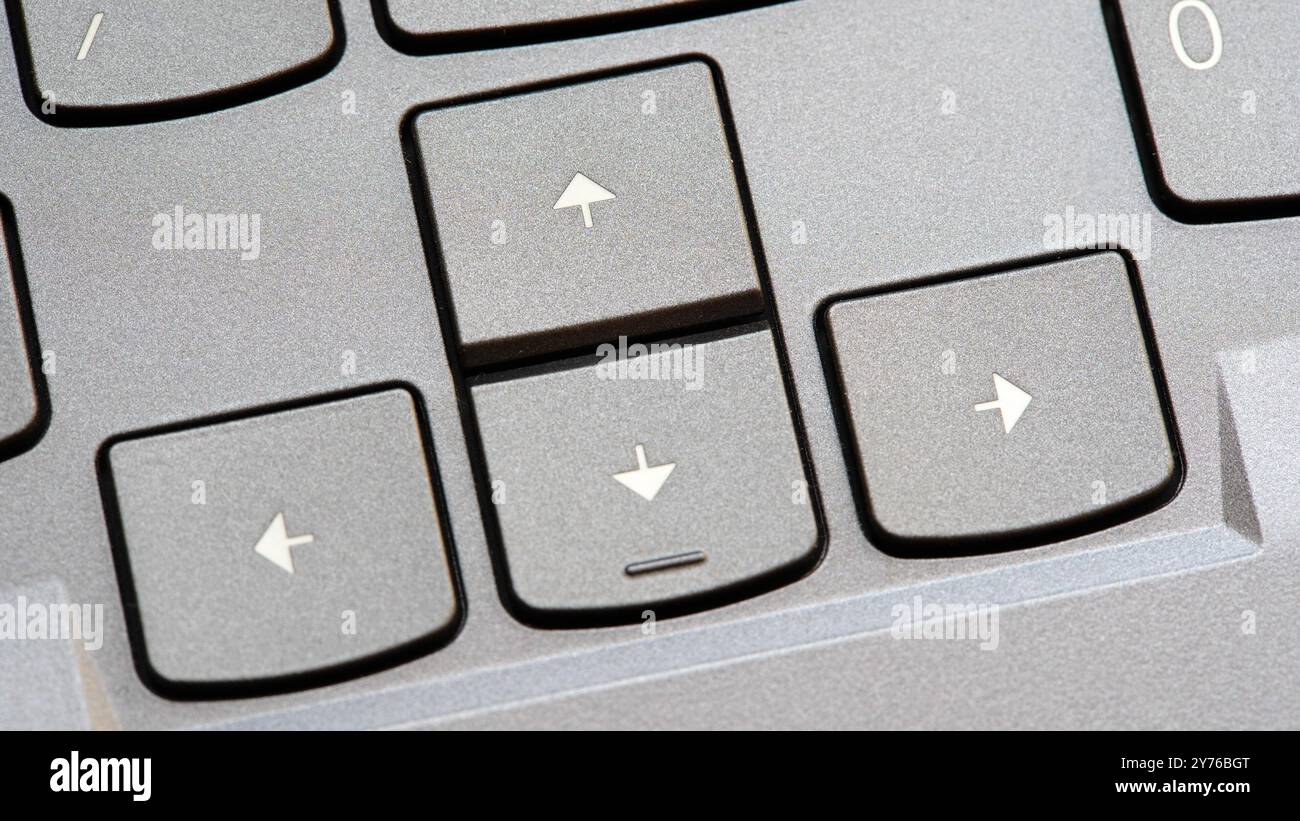 Gray arrow keys on a new modern laptop keyboard, high angle, top view ...