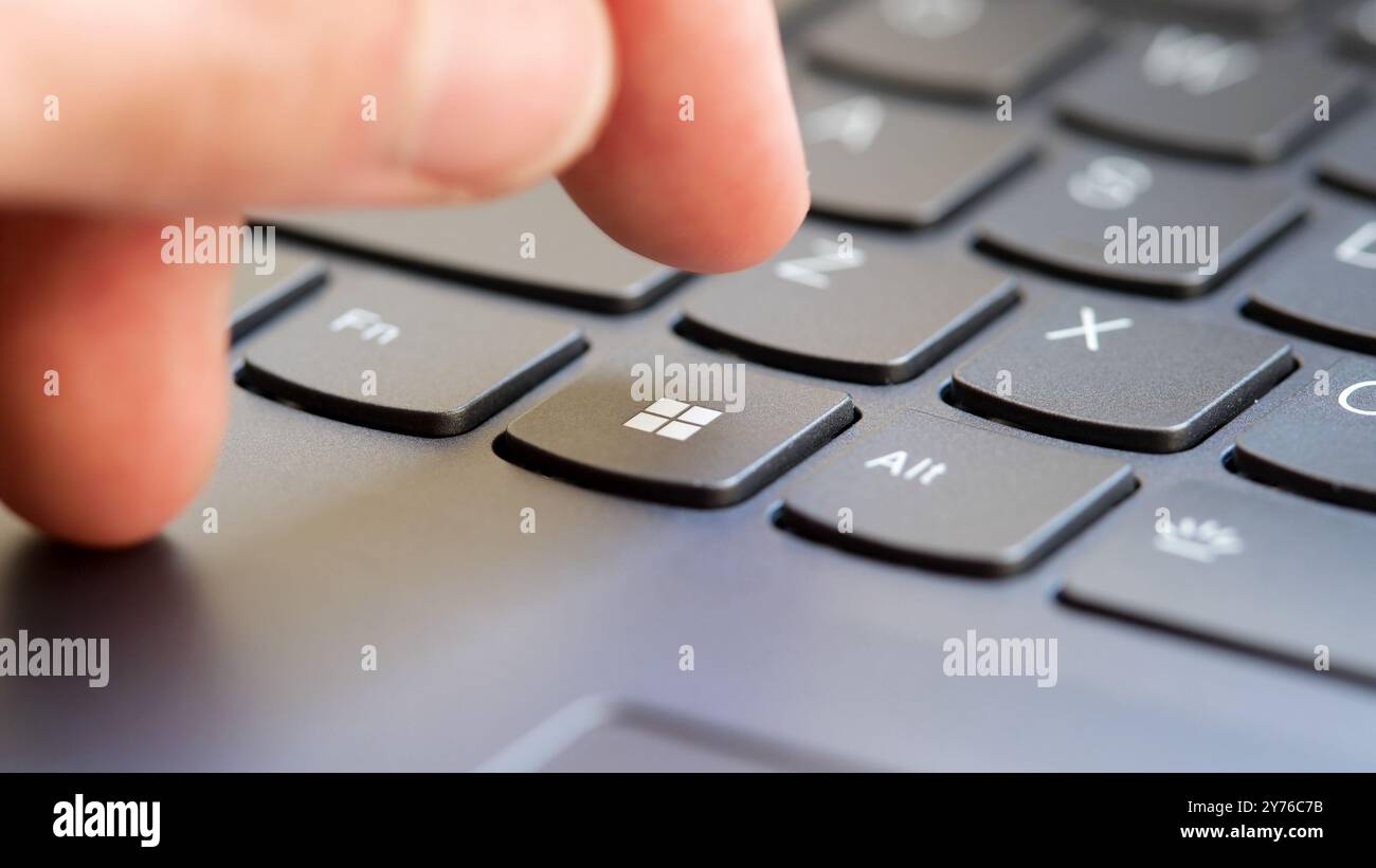Man pressing the Windows 11 10 system key on a new modern laptop ...