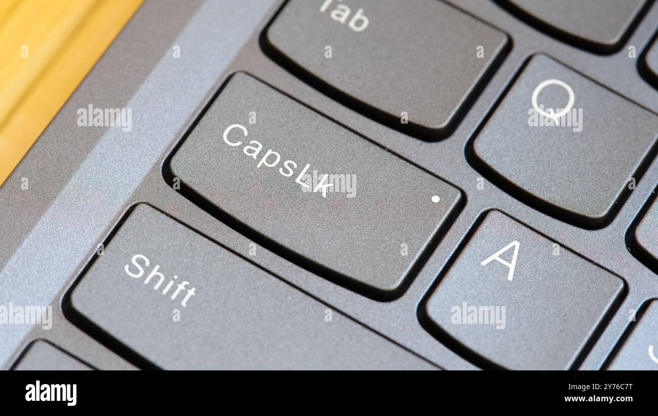 Man pressing the Capslock key on a modern laptop computer keyboard ...