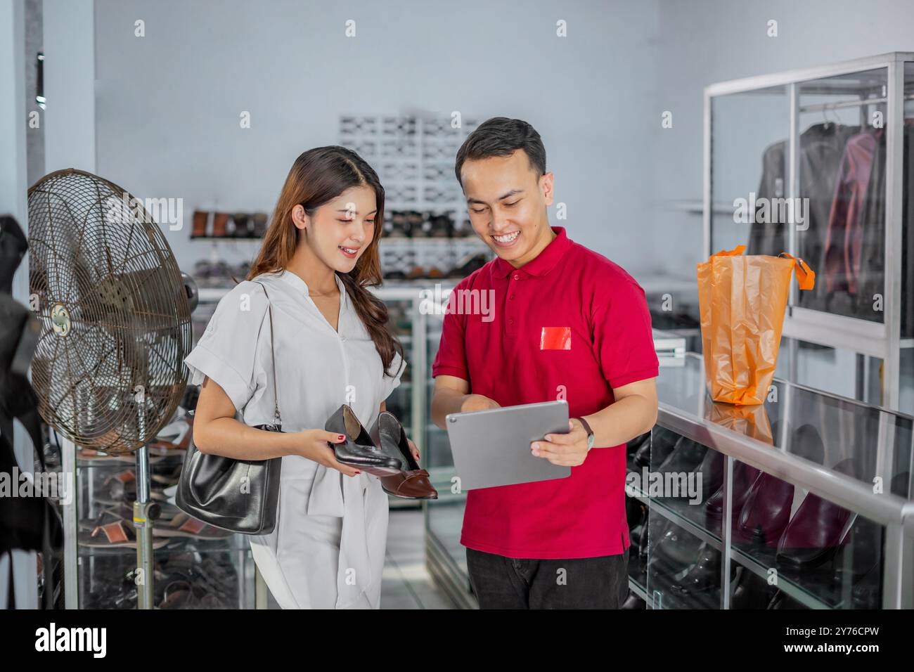 professional male staff helping customer checking leather shoes product using tablet Stock Photo ...