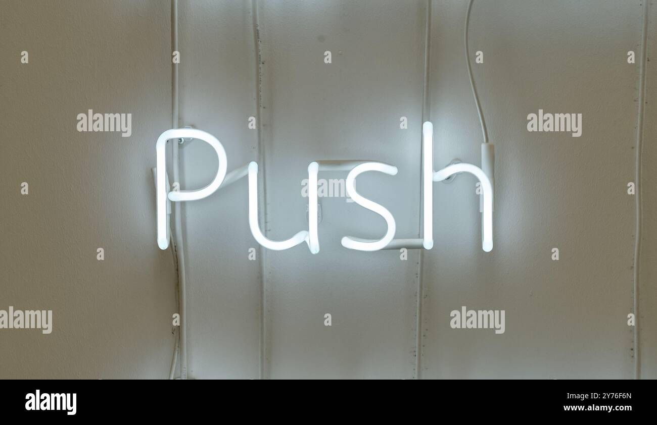 Neon sign with Push lettering on white wall Stock Photo - Alamy