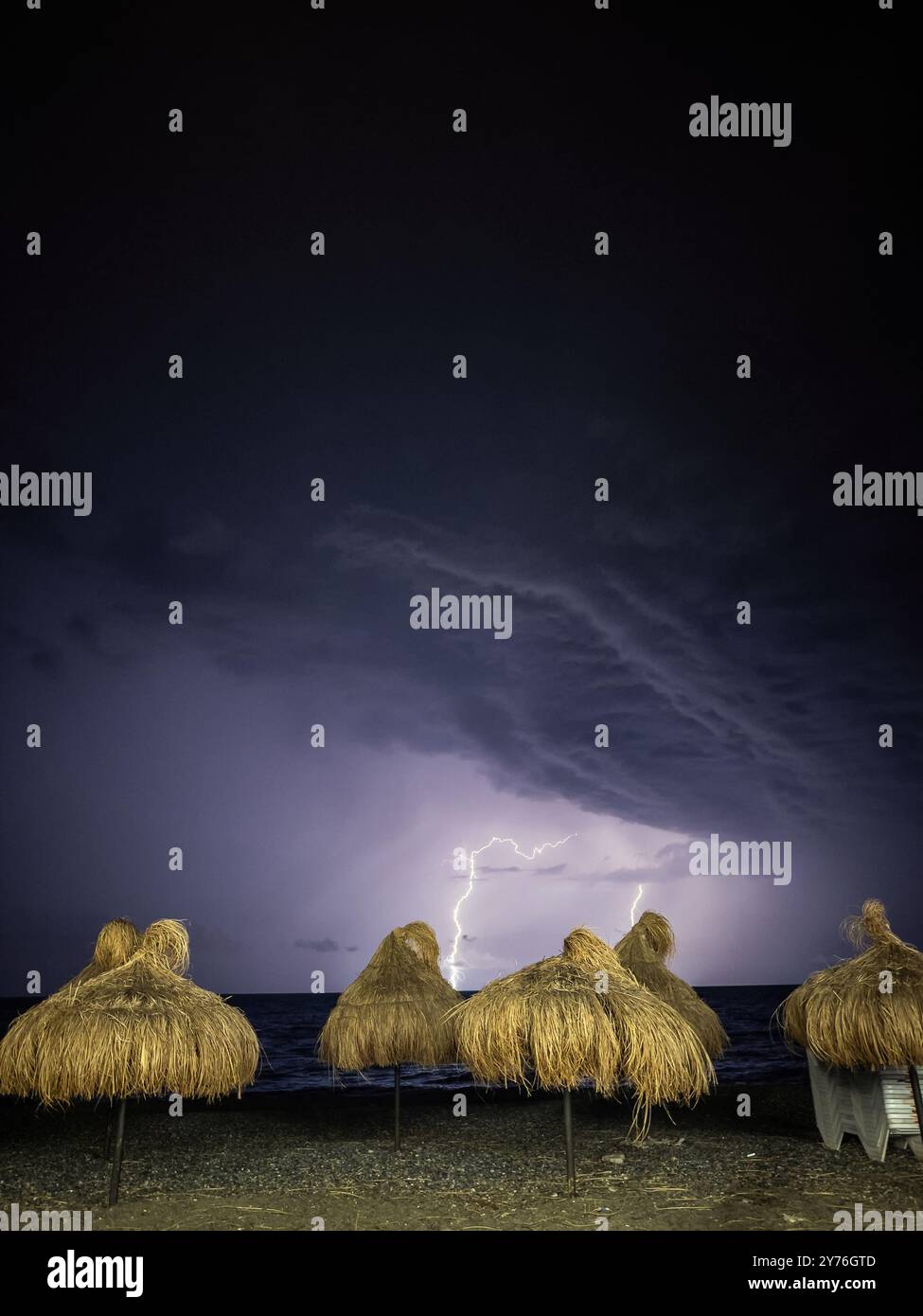 Lightning Over Beach Umbrellas Stock Photo - Alamy