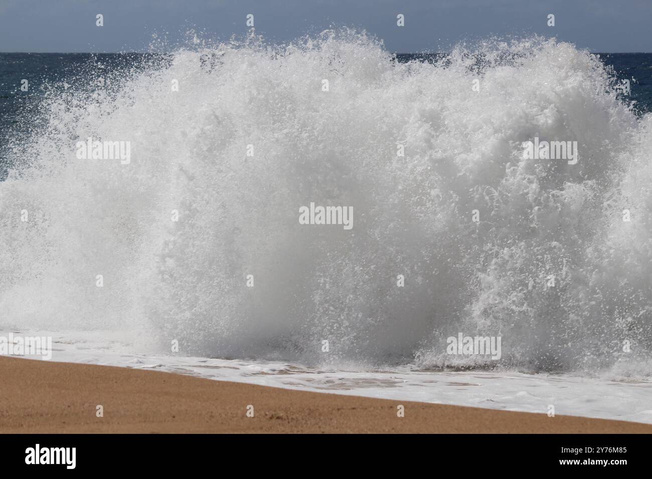 A dynamic moment of a powerful ocean wave crashing onto the shore Stock ...