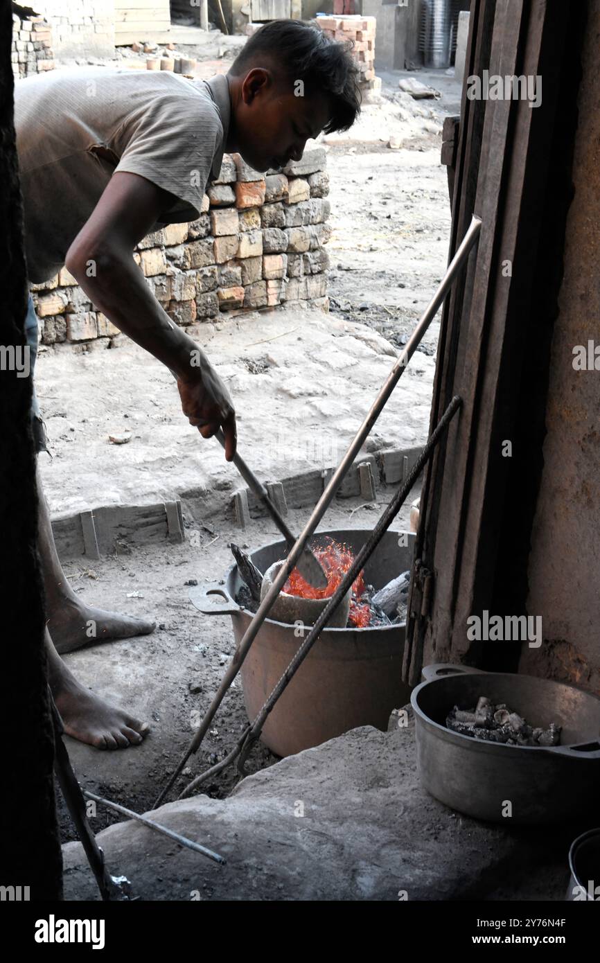 Ambatolampy, artisanal aluminium foundery. Worker with crucible with ...