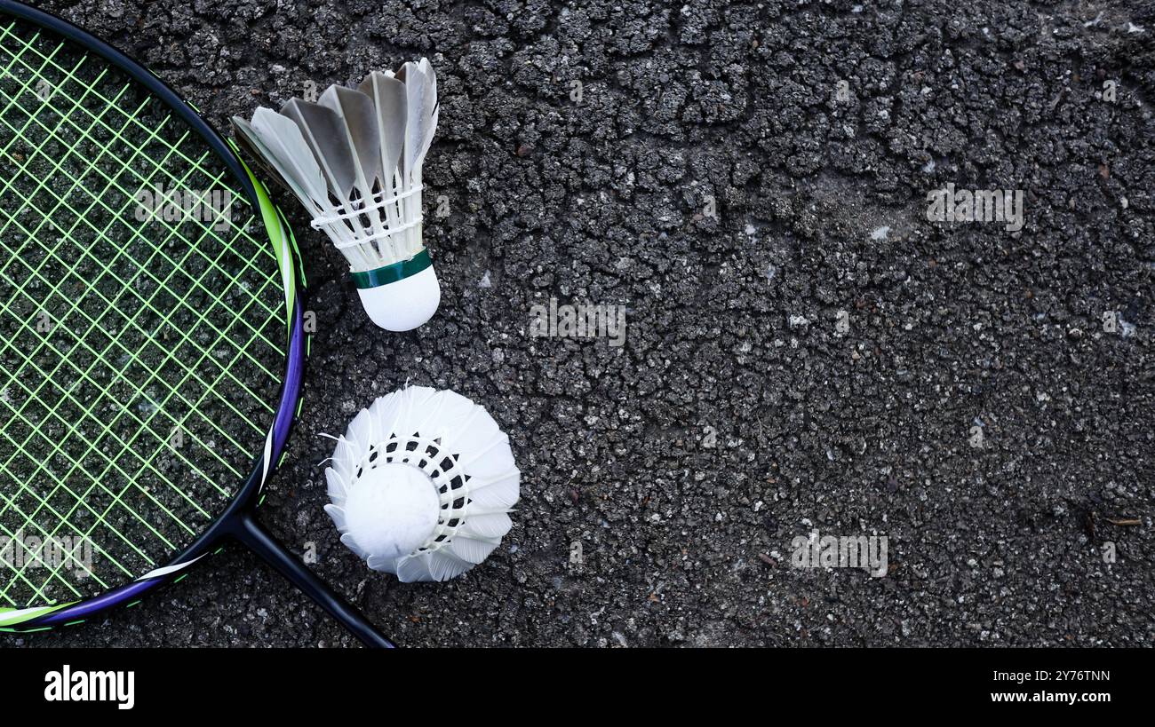 Closeup badminton shuttlecock and badminton racket on dark dirt ...