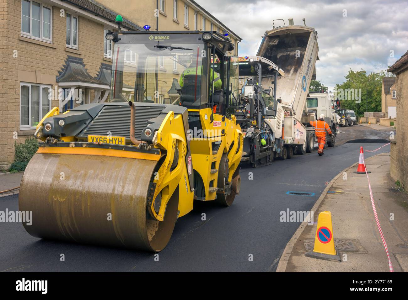 A team of workman operating heavy machinery to resurface a residential ...