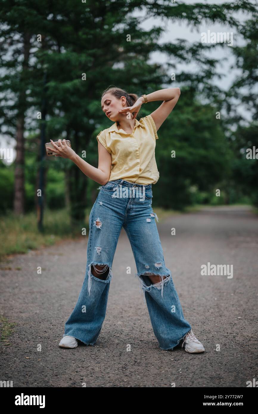 Girl enjoying herself alone in the park with a playful pose Stock Photo ...