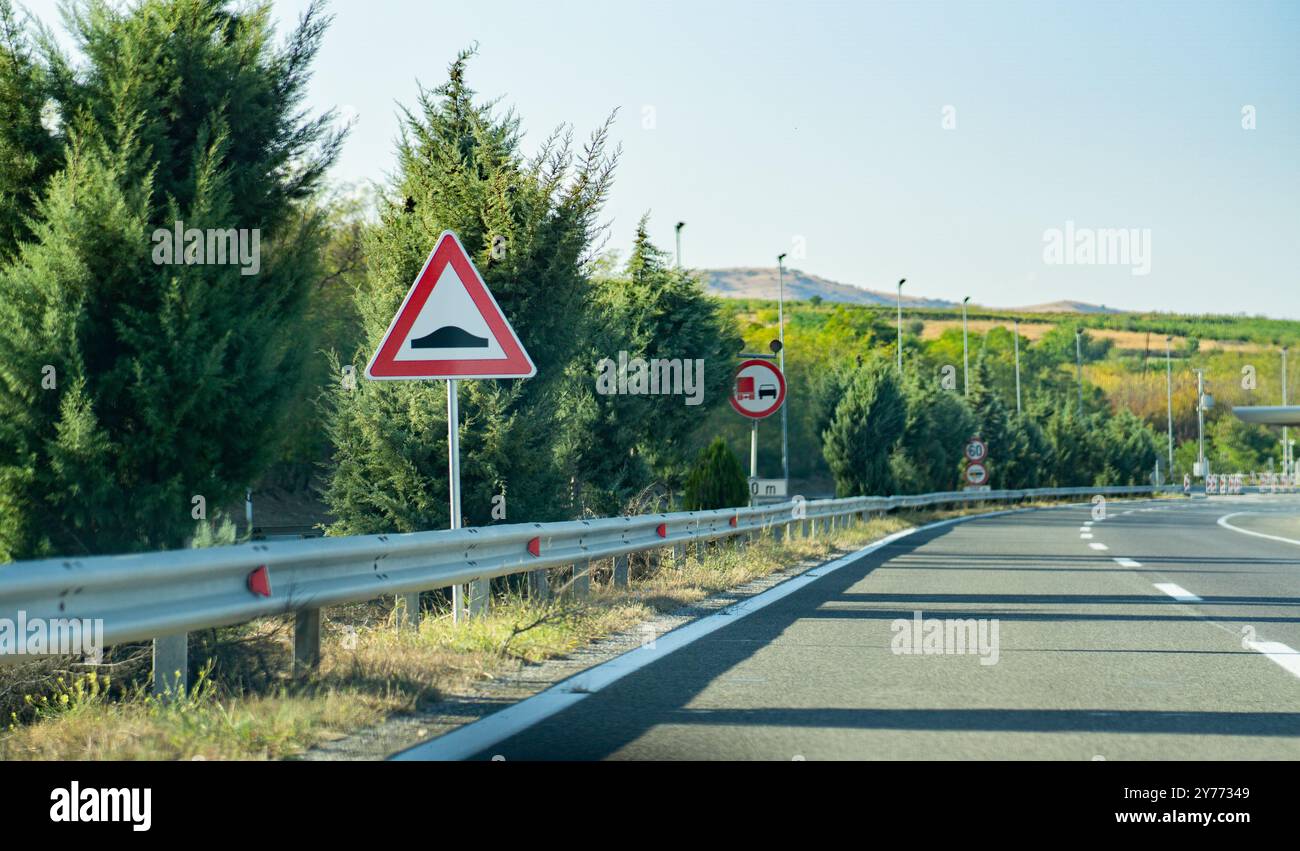 Uneven road traffic sign on highway Stock Photo - Alamy