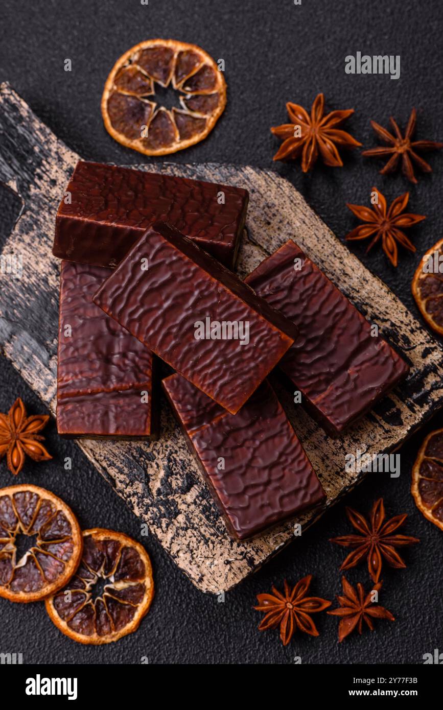 Rectangular chocolate candies with mousse and waffles on a dark ...