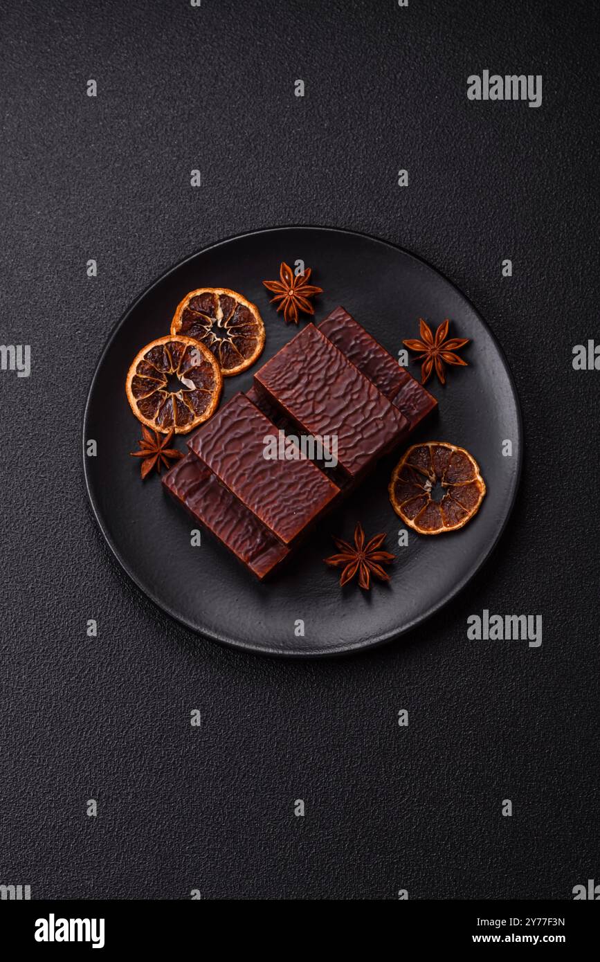 Rectangular chocolate candies with mousse and waffles on a dark ...
