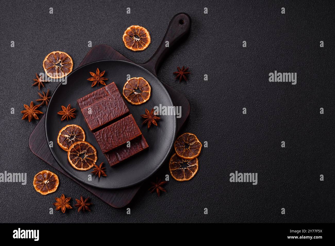 Rectangular chocolate candies with mousse and waffles on a dark ...