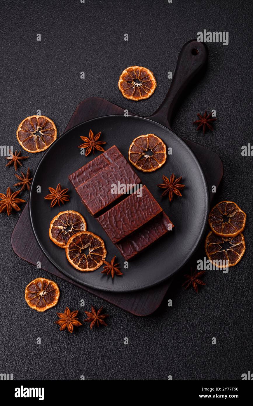 Rectangular chocolate candies with mousse and waffles on a dark ...