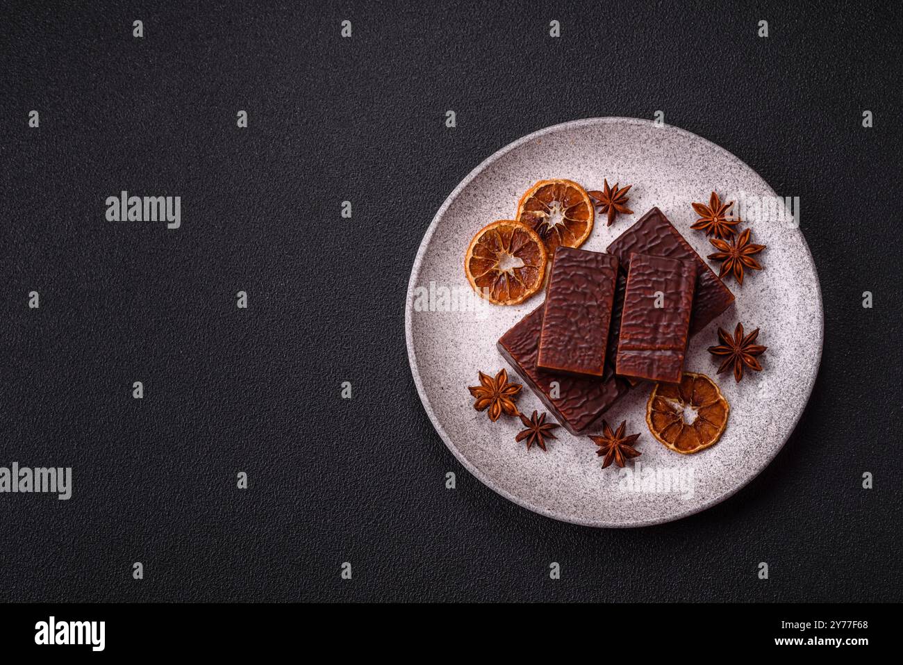 Rectangular chocolate candies with mousse and waffles on a dark ...