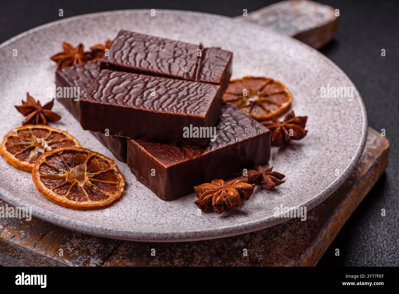 Rectangular chocolate candies with mousse and waffles on a dark ...