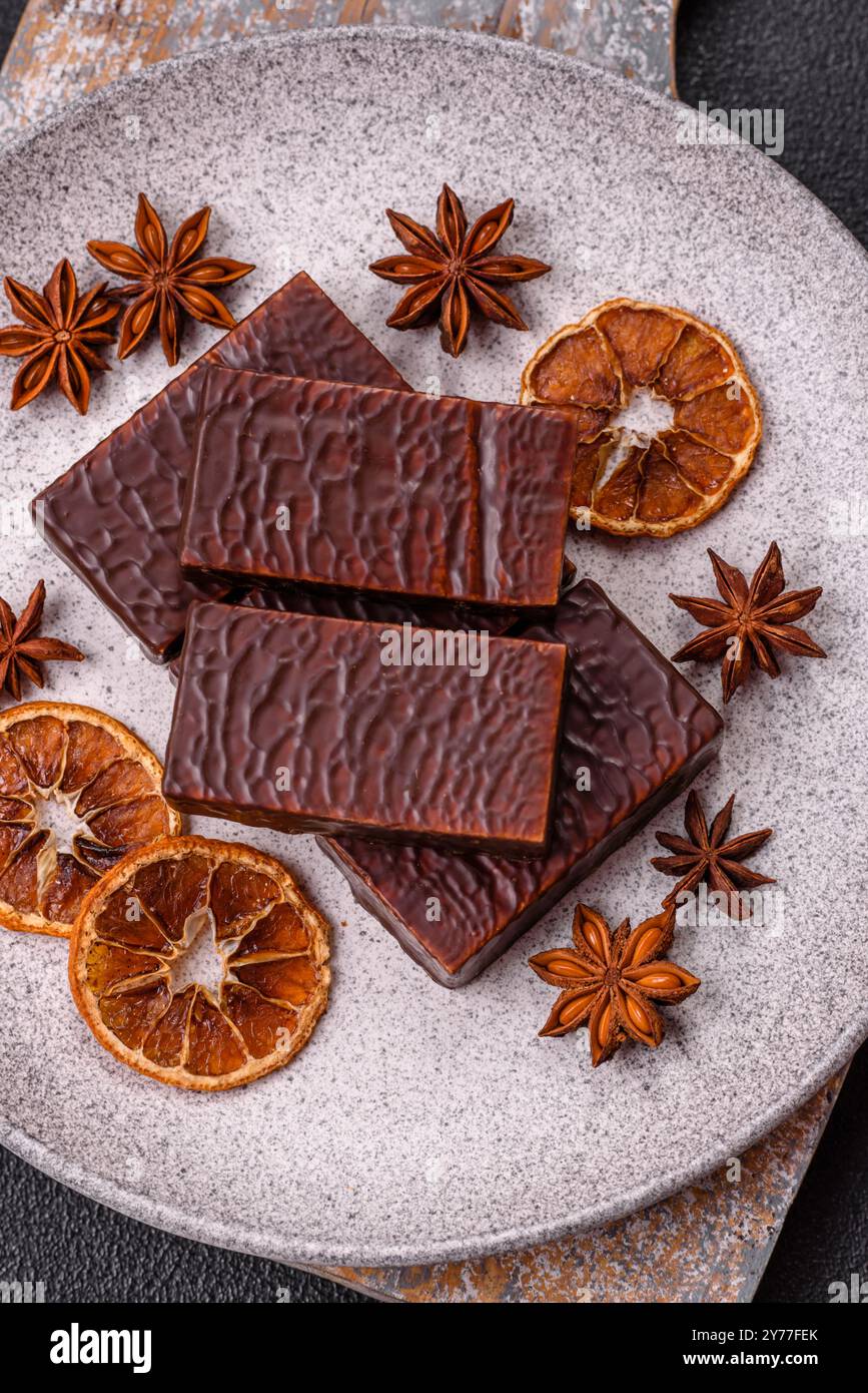 Rectangular chocolate candies with mousse and waffles on a dark ...