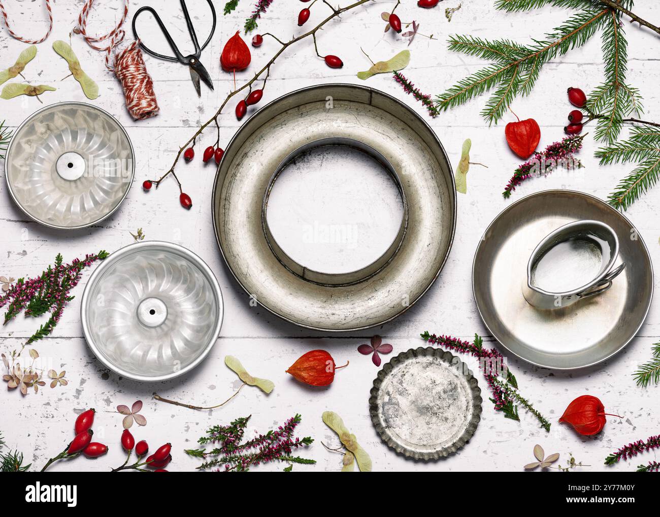 Top view of workplace with metal baking pan, water, red rose hips ...