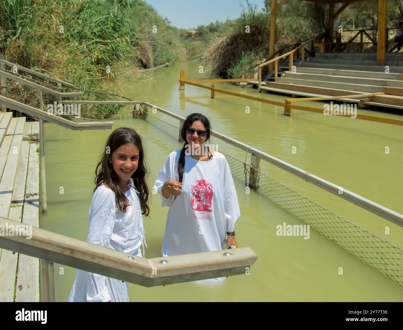 Pilgrims with white clothes going into the water of the Jordan river at ...