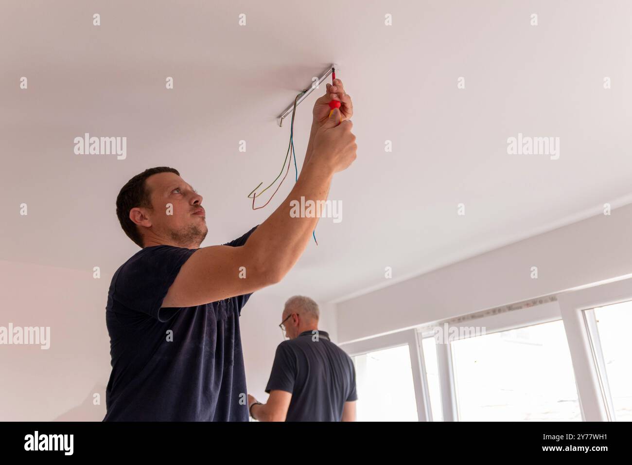 Concept installation of a ceiling led light. Hands of an electrician ...