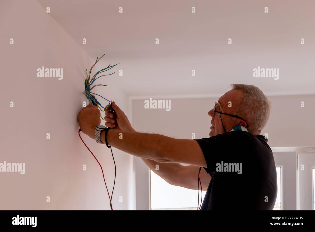 Electrician, examines the cable connection in the electrical line ...