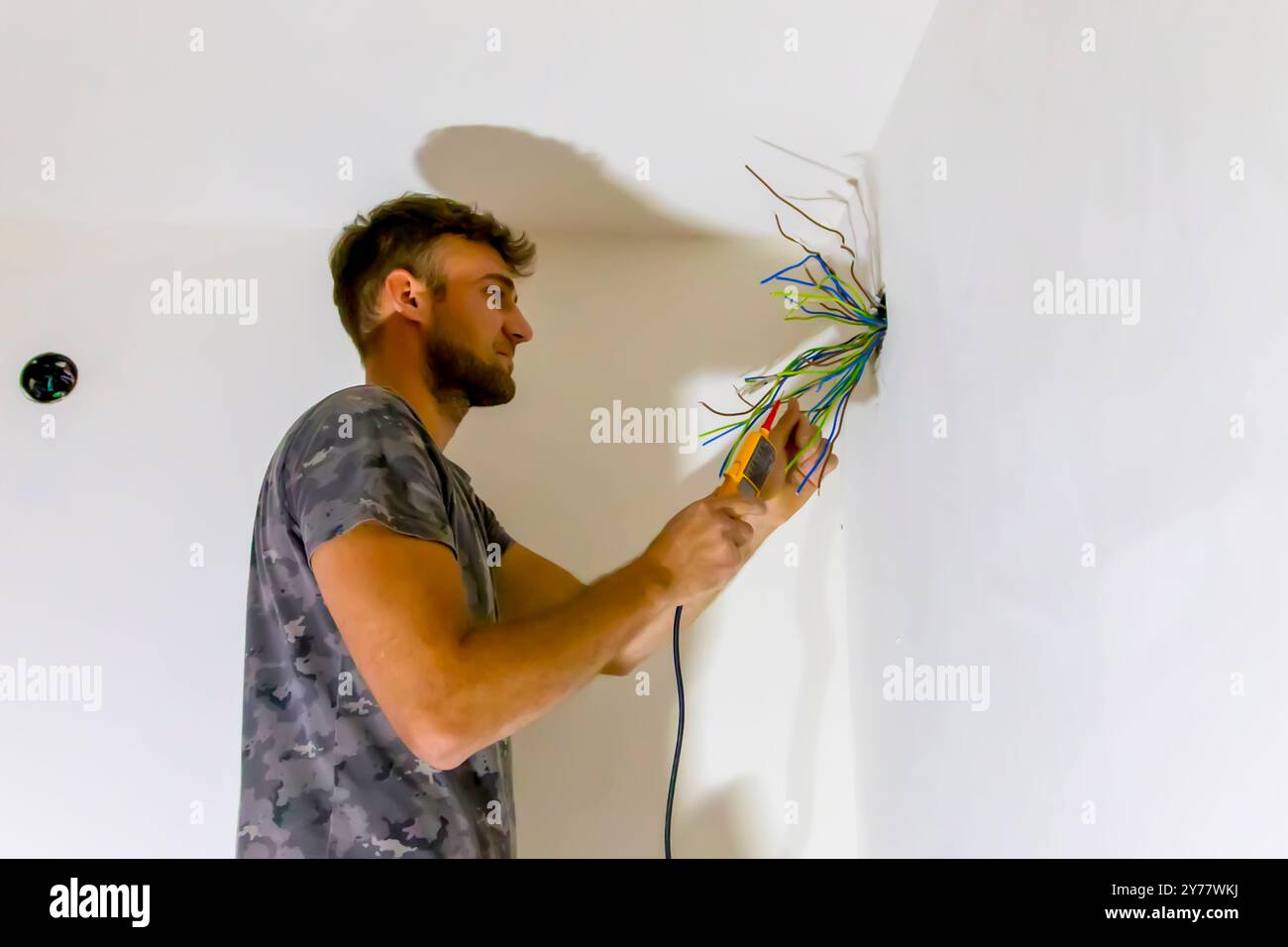 Electrician, examines the cable connection in the electrical line ...