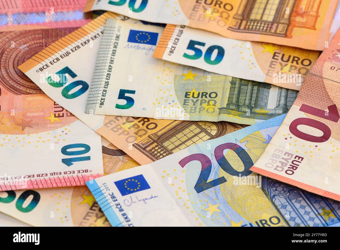 The background consists of many euro banknotes of different ...