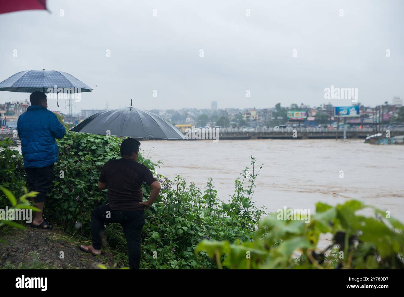 People look at the overflown Bagmati river due to heavy rainfall ...