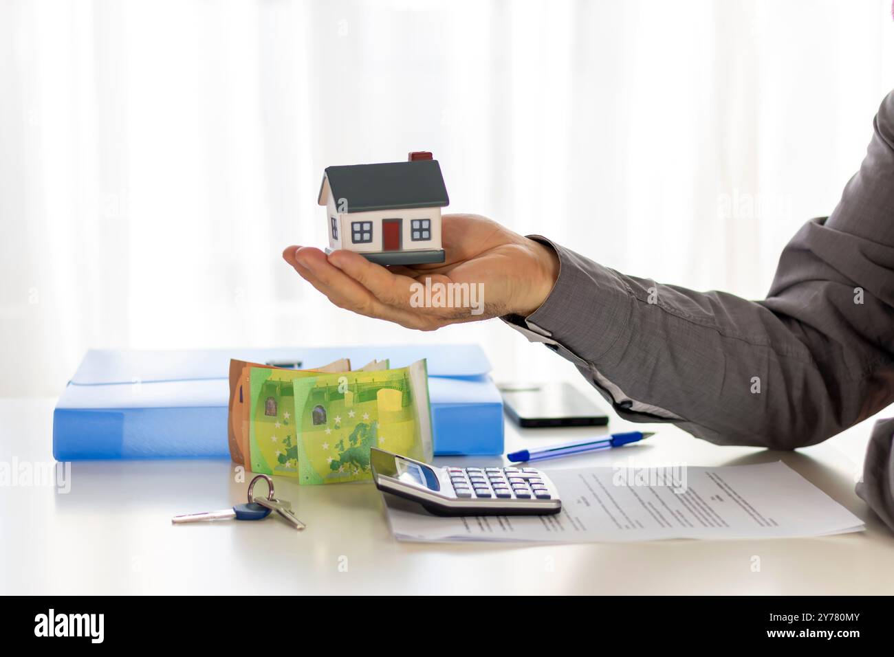 Real estate broker holding key and house model. Offer of purchase house ...