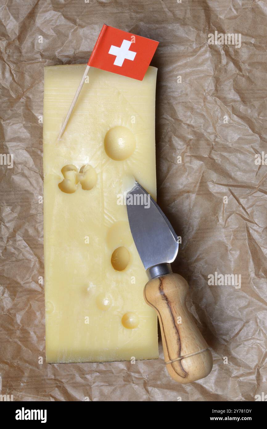 A piece of Swiss Emmental cheese and the Swiss flag Stock Photo - Alamy