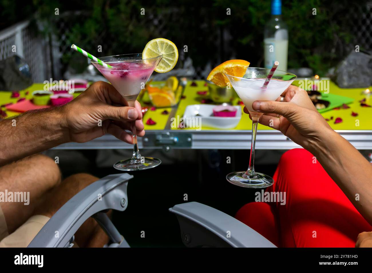 Happy romantic couple celebrating, holding glasses of cocktails with ...