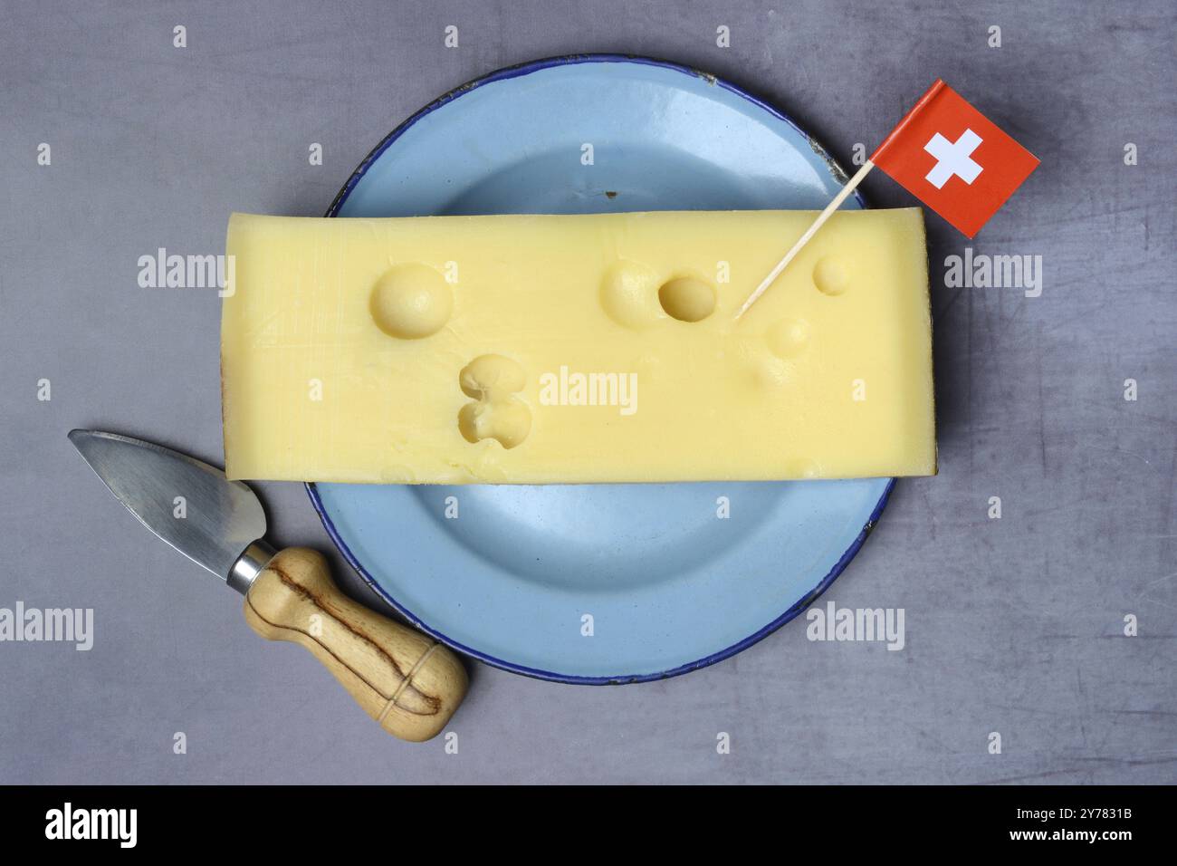 A piece of Swiss Emmental cheese on a plate and the Swiss flag Stock ...