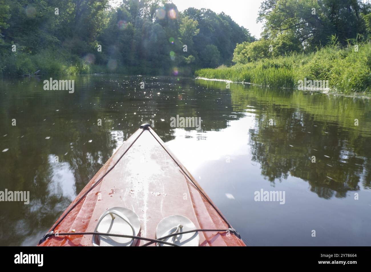 Red plastic kayak on the water, sun rays and kayak Stock Photo - Alamy
