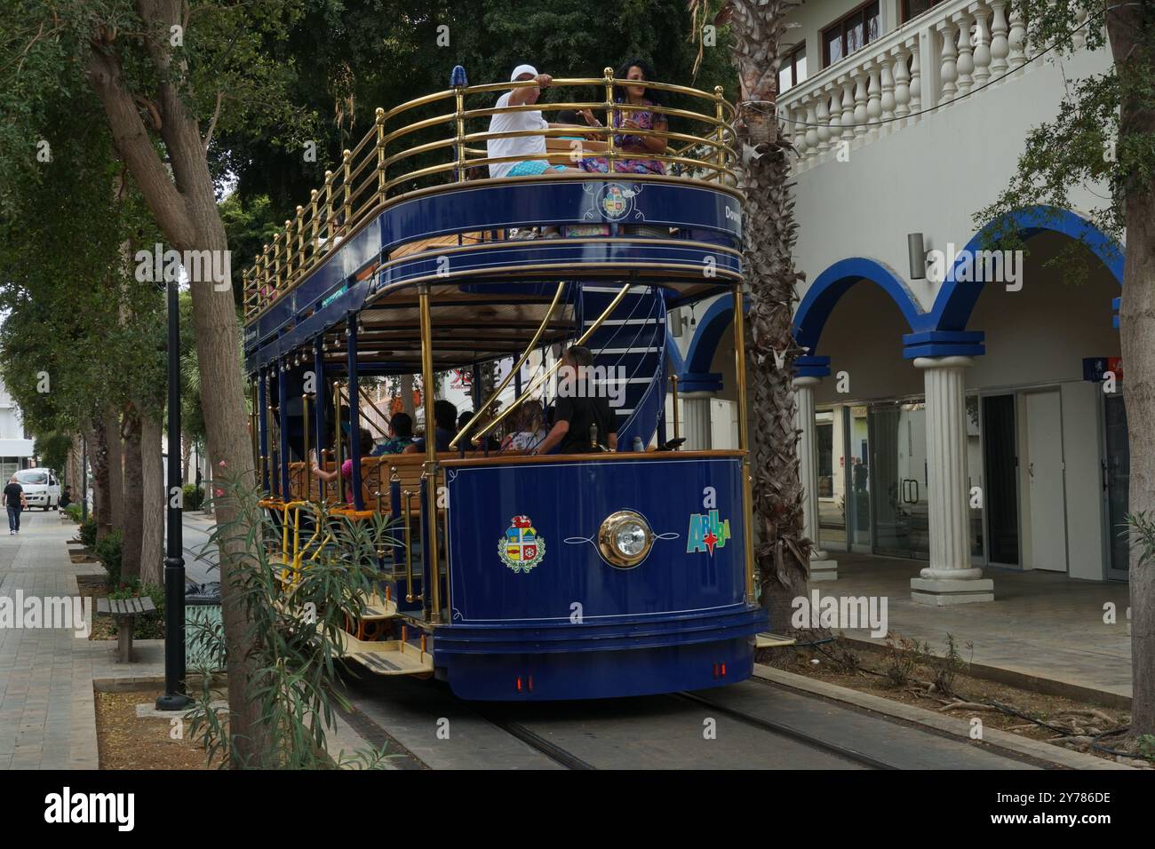Downtown trolley or streetcars full of tourist passing narrow street ...