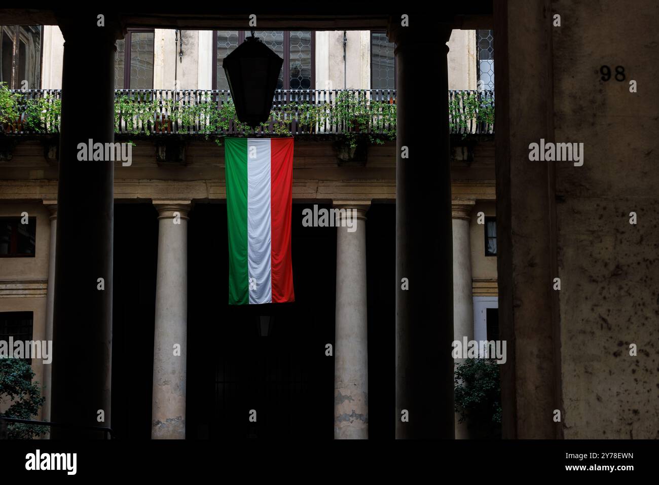 Glimpse of the typical ancient italian courtyard with the Italian flag ...
