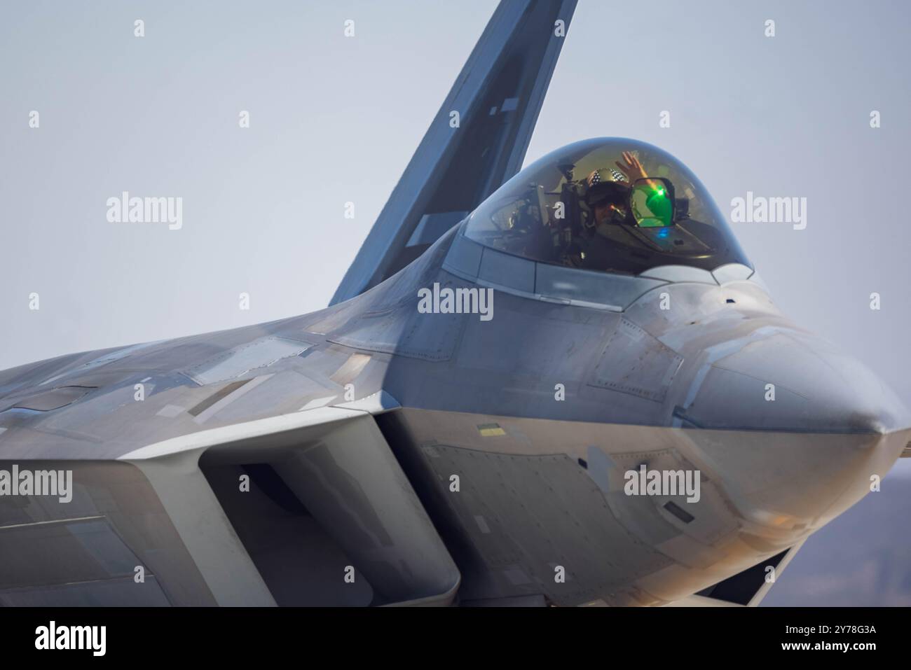 A U.S. Air Force pilot waves at spectators from an F-22 Raptor during ...
