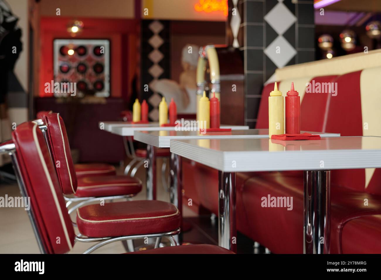 Retro-style diner with classic red and yellow dining booth, condiment ...
