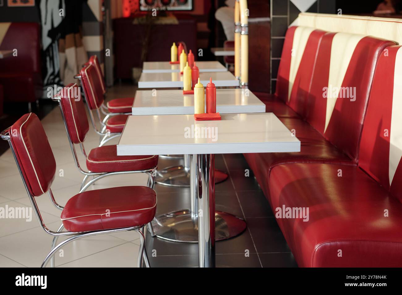 Interior of retro diner showcasing rows of red leather seats and white ...