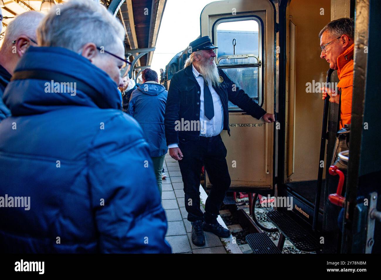 An inspector is seen helping people to go in and out of the locomotive ...