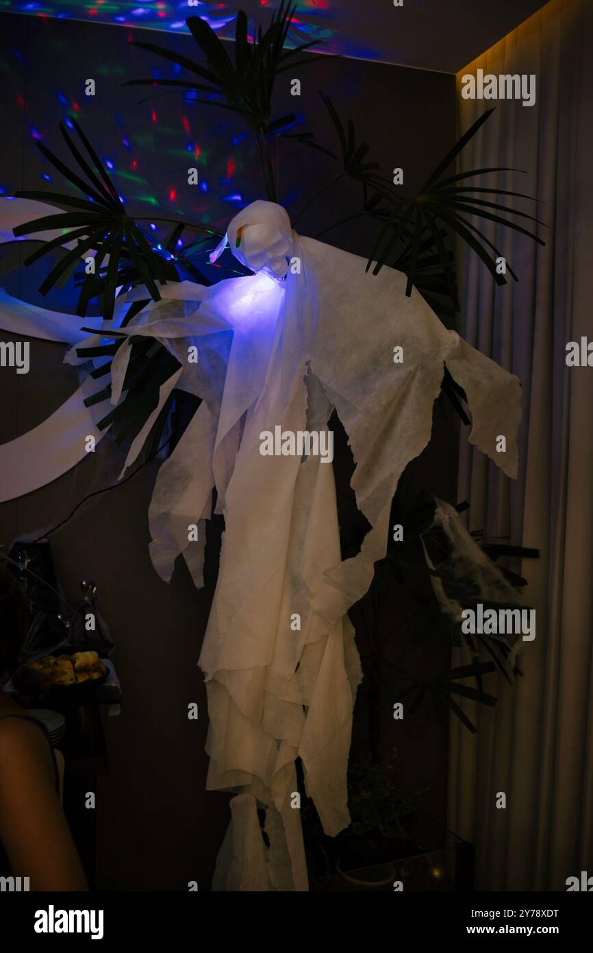 A ghostly figure made of white paper is lit up with blue lights. The ...
