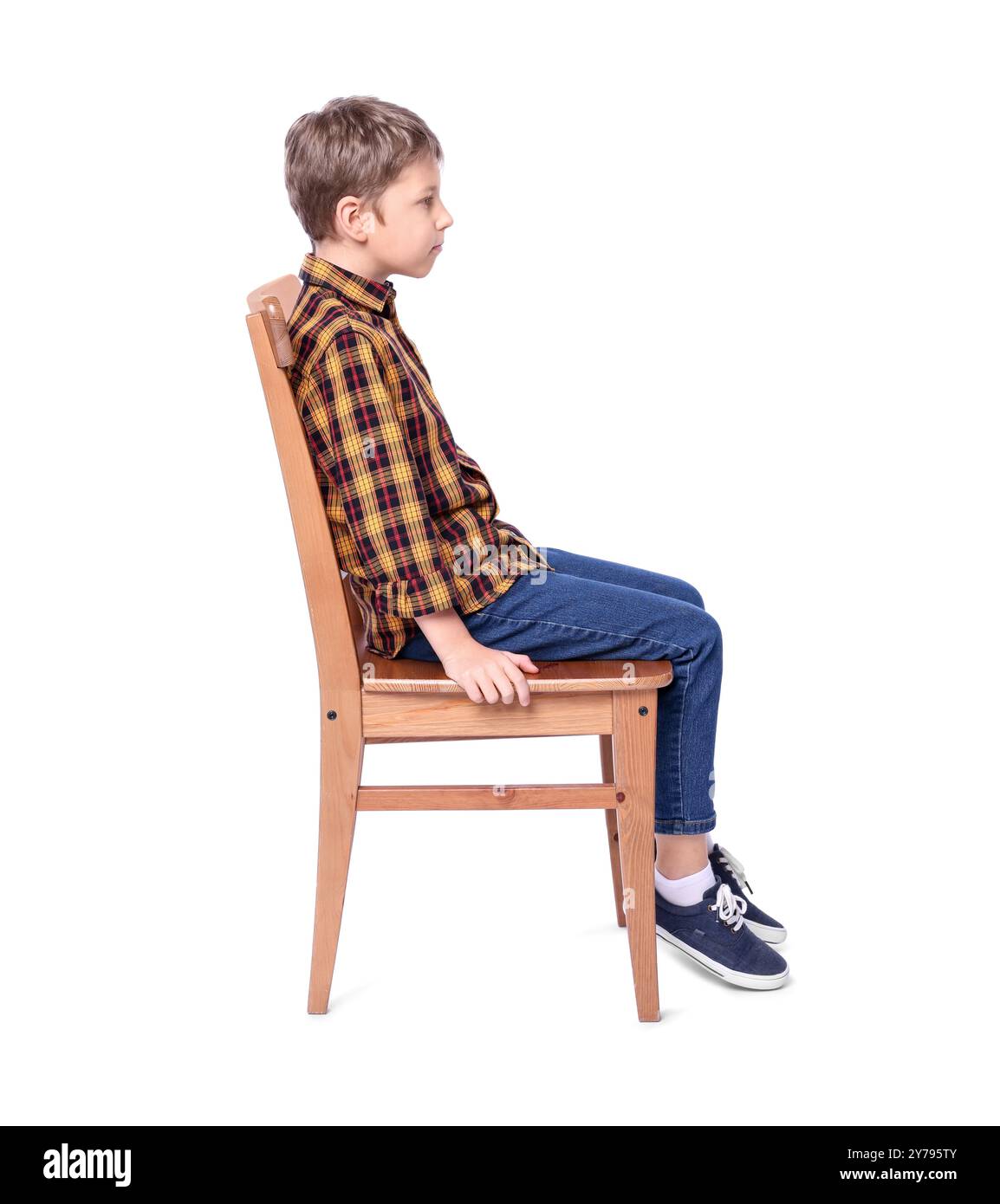 Boy with correct posture sitting on chair against white background Stock Photo - Alamy