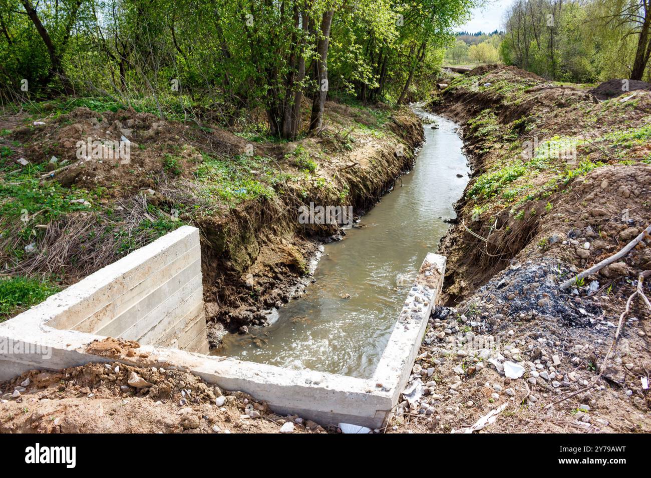 Channel with water flowing out of a tunnel under a road Stock Photo - Alamy