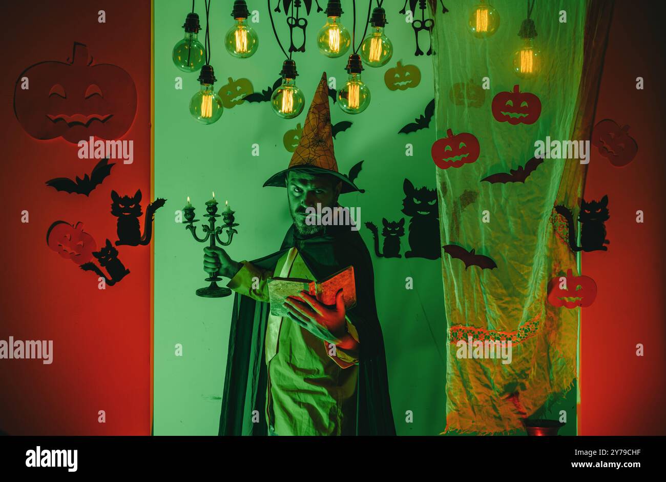 Happy father on halloween background with magik book. Man pronounces a ...