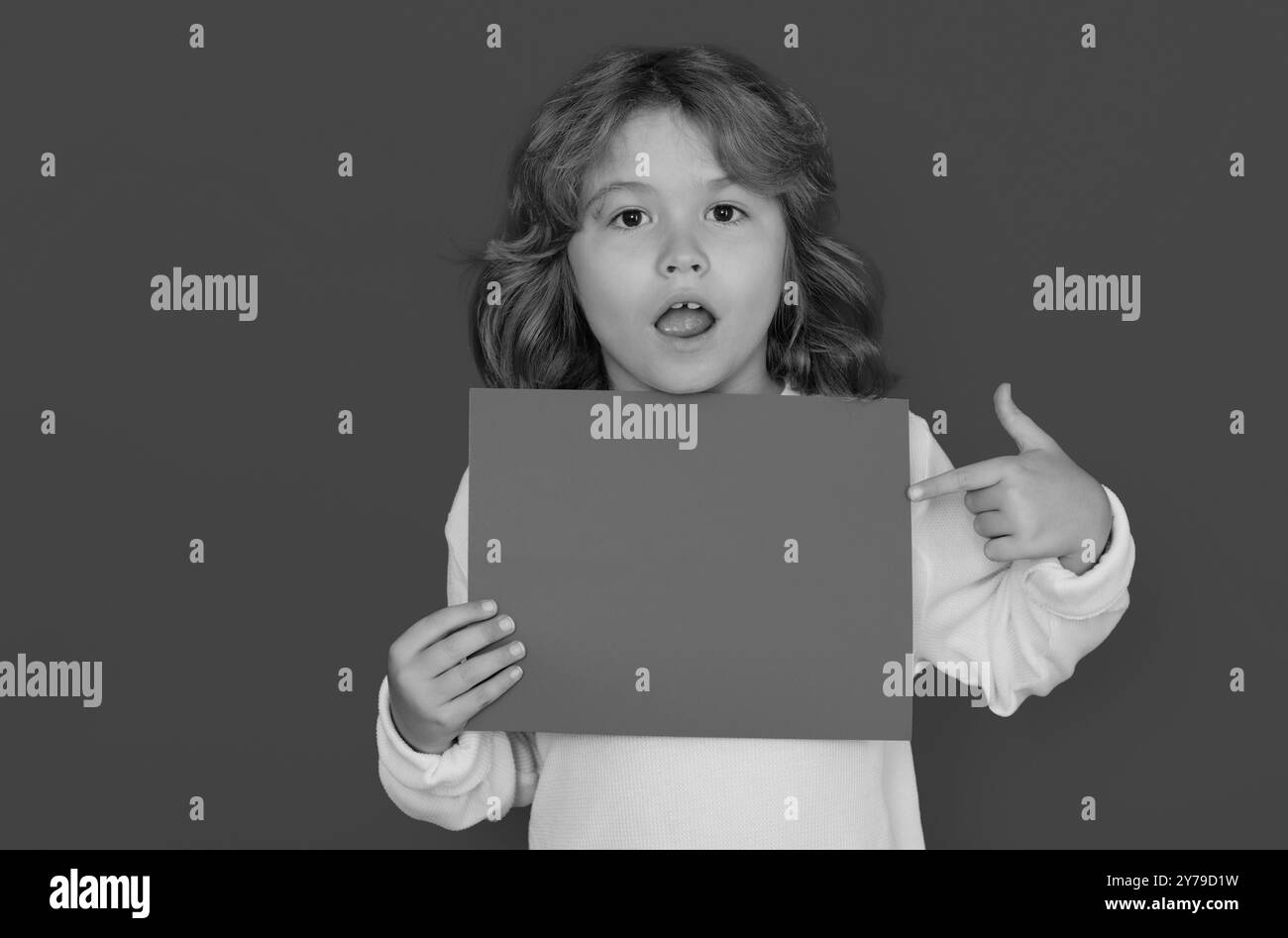 Funny kid showing index finger on green empty sheet of paper, isolated ...
