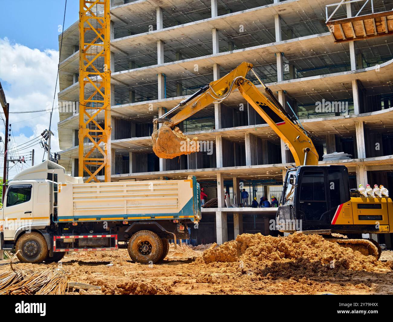 Excavator loads ground into a dump truck at a construction site Stock ...