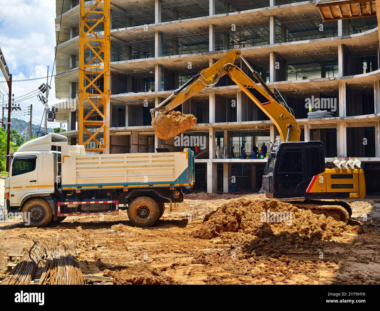 Excavator loads ground into a dump truck at a construction site Stock ...