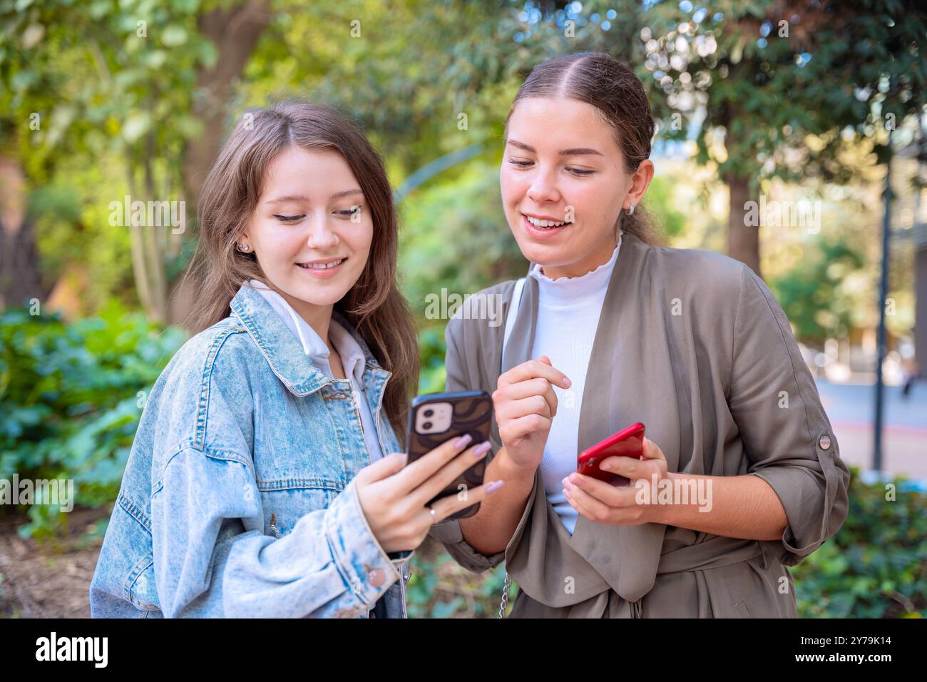 two happy teenage friends using smartphone app outdoors Stock Photo - Alamy