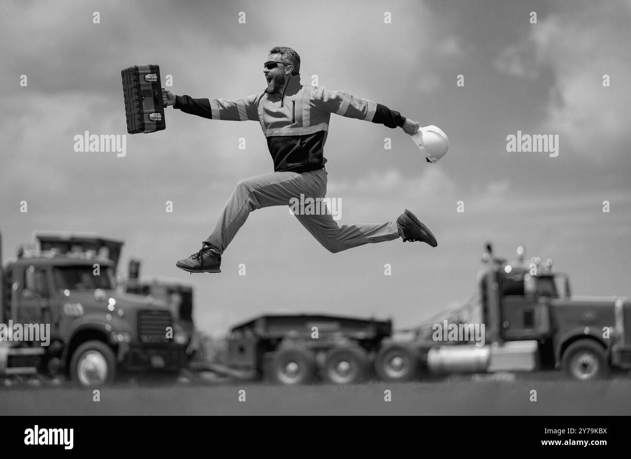 Construction man excited jump with helmet. Worker at construction new ...
