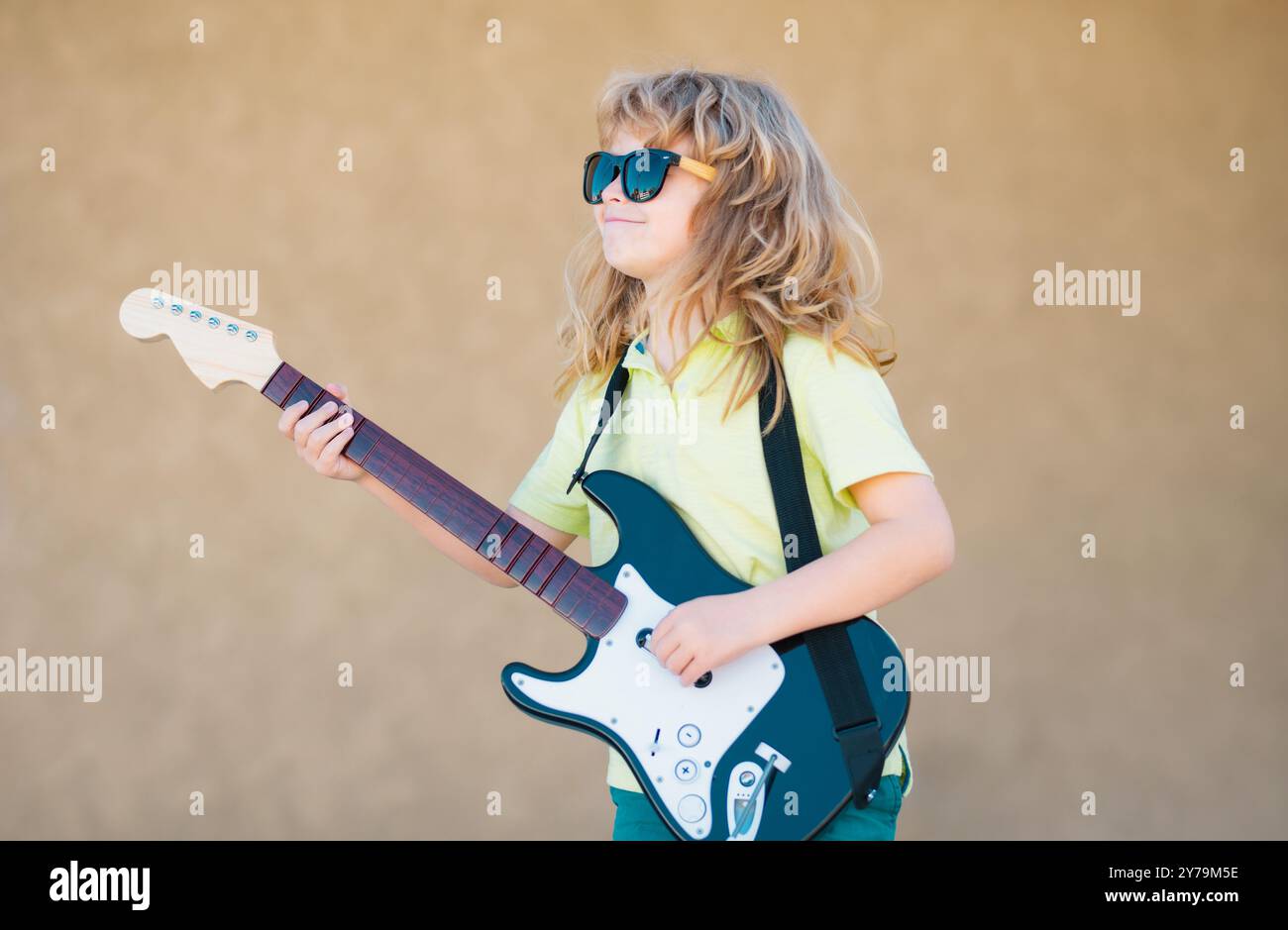 Little boy playing guitar outdoor. Child musician playing the guitar ...
