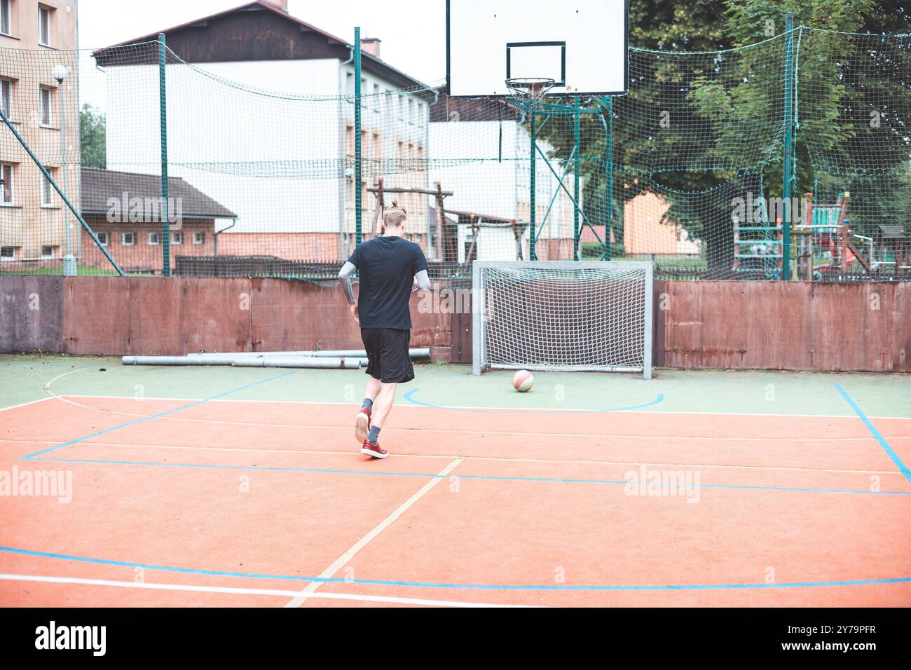 Young man runs towards the goal, preparing to shoot a football. The ...