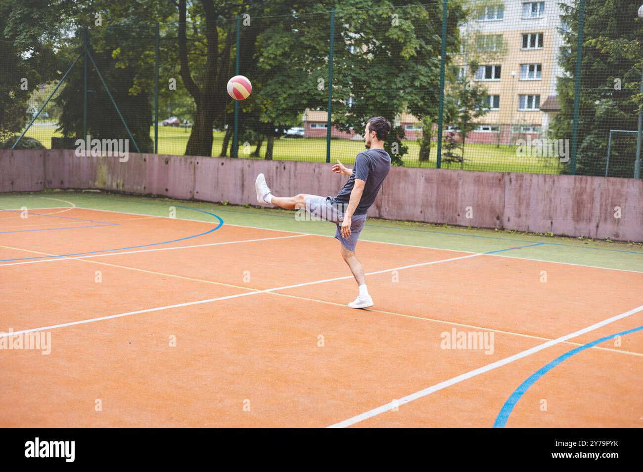 Young man takes a powerful shot on goal while playing football on an ...